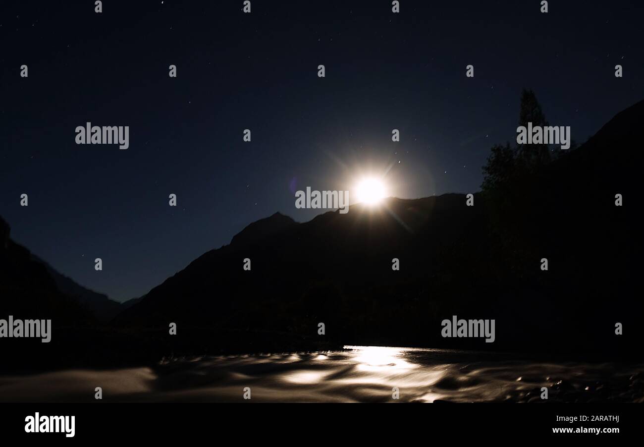 The moon shining over a river inside the Himalaya Stock Photo - Alamy