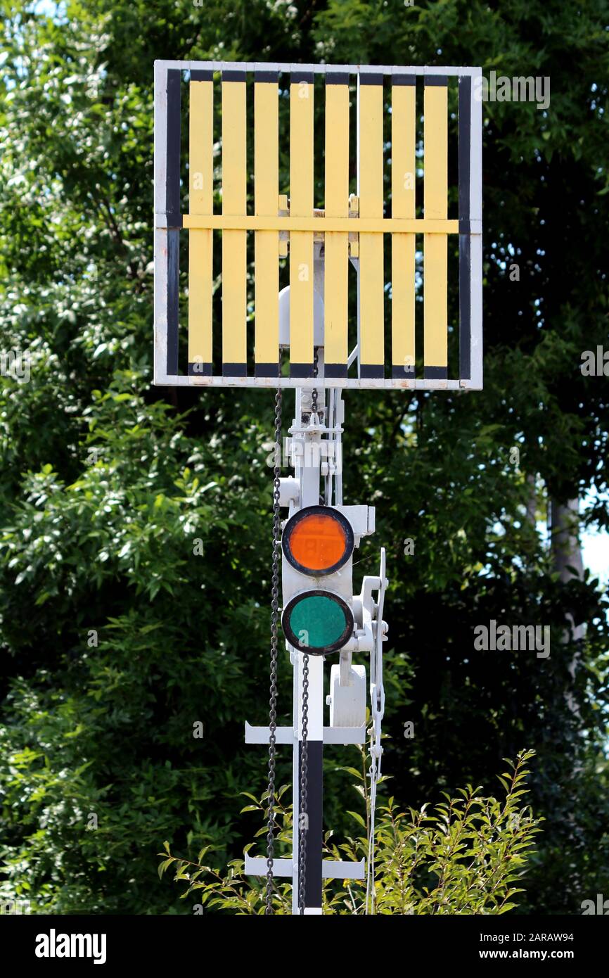 Railway trackside red and green traffic signal lights below signal sign ...