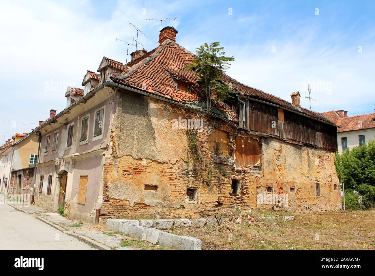 Ruins of large old abandoned suburban family house with destroyed cracked walls and boarded ...