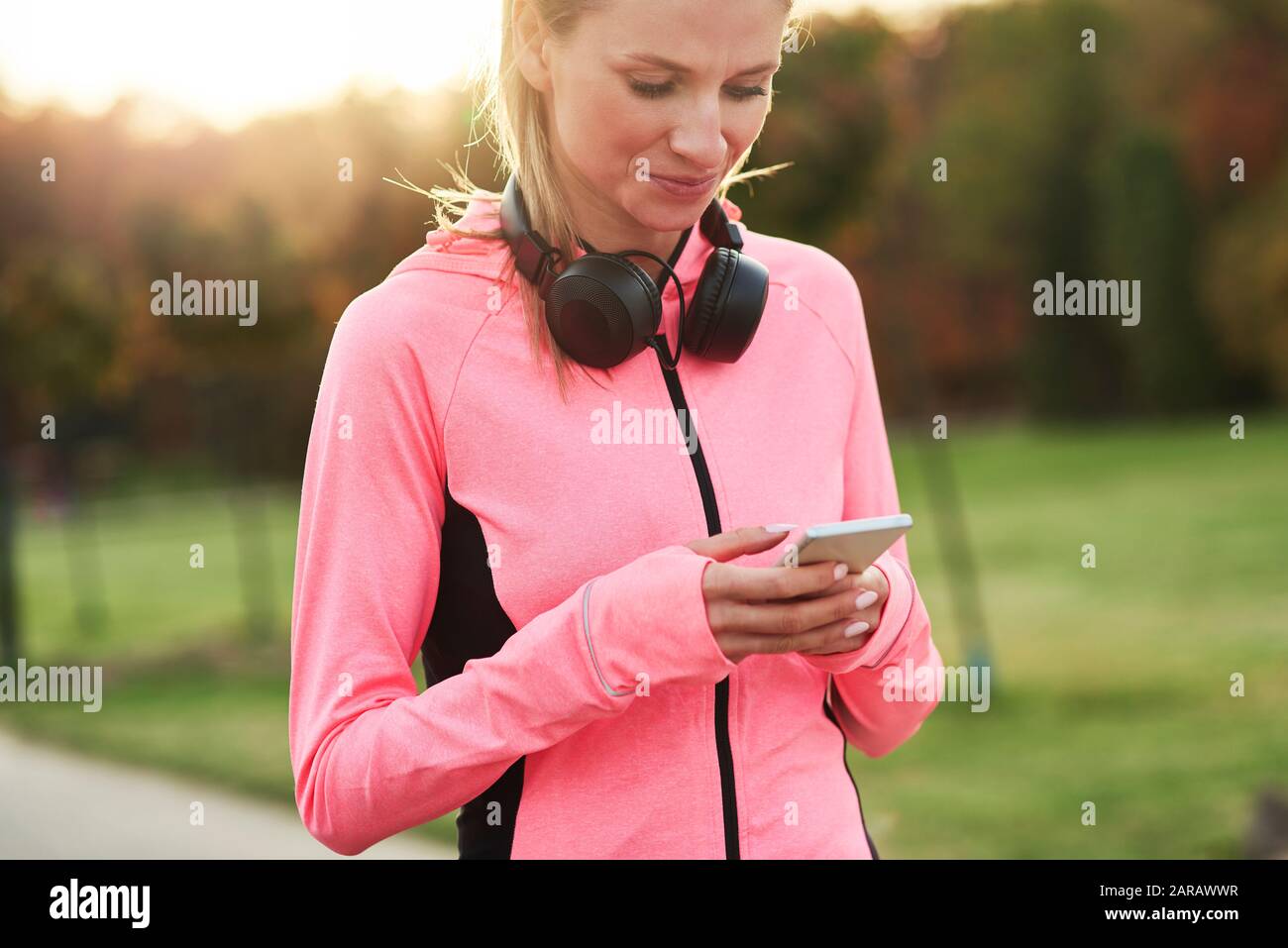 Female athlete using mobile phone during jogging training Stock Photo ...