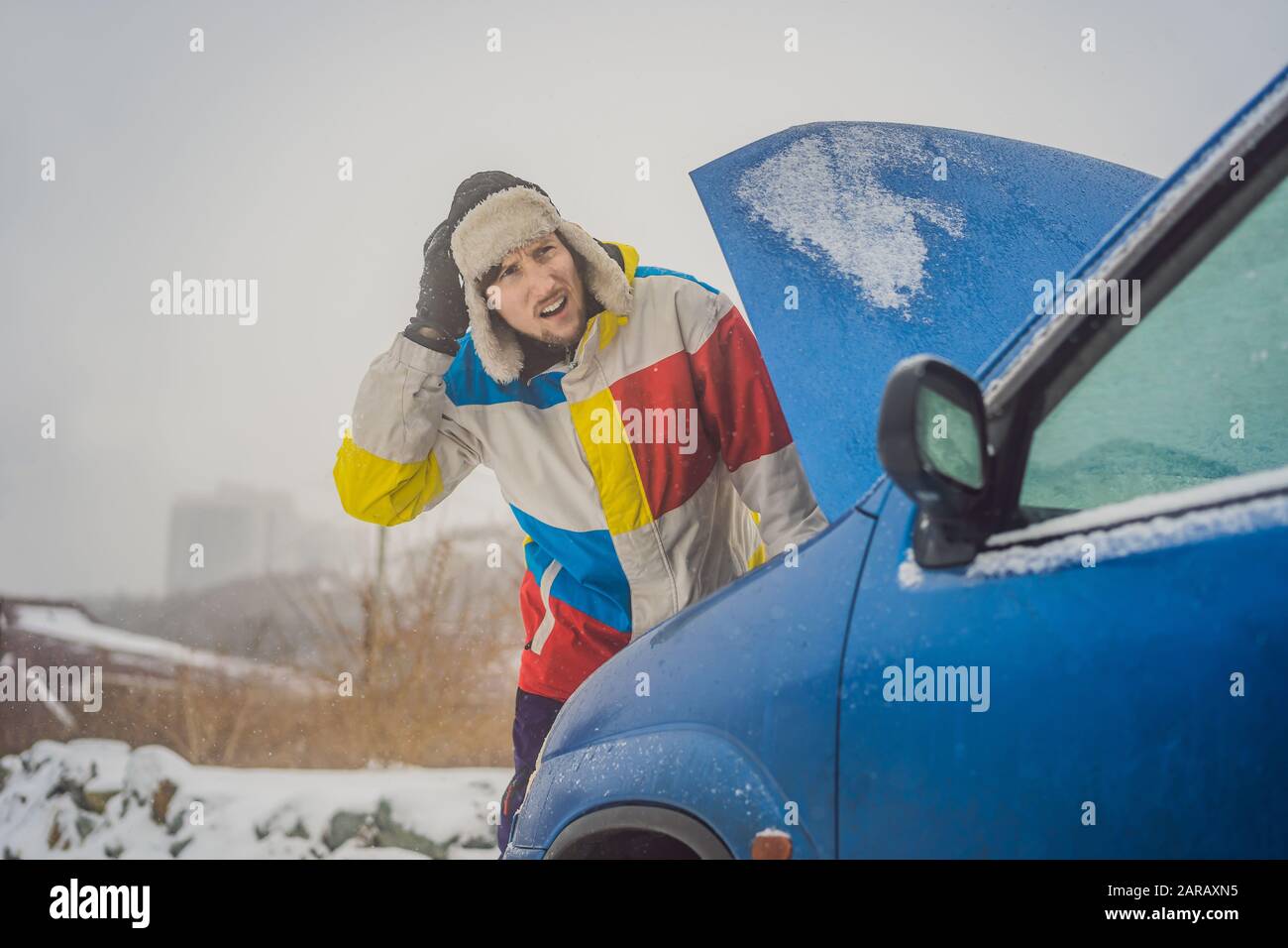 Man looking under car hood of broken down car hi-res stock photography ...