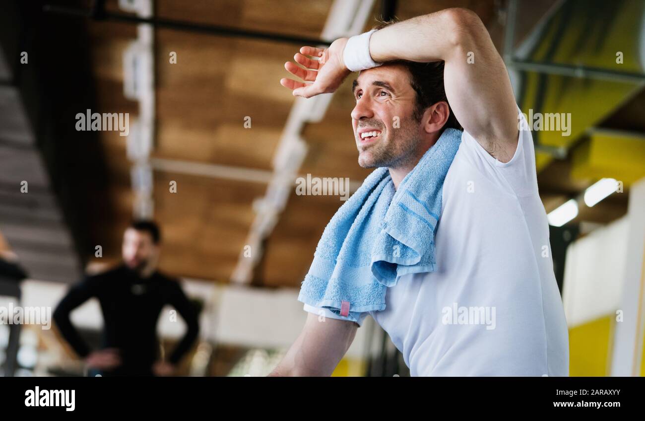 Sweaty after great work out. Handsome young men in sportswear whipping ...