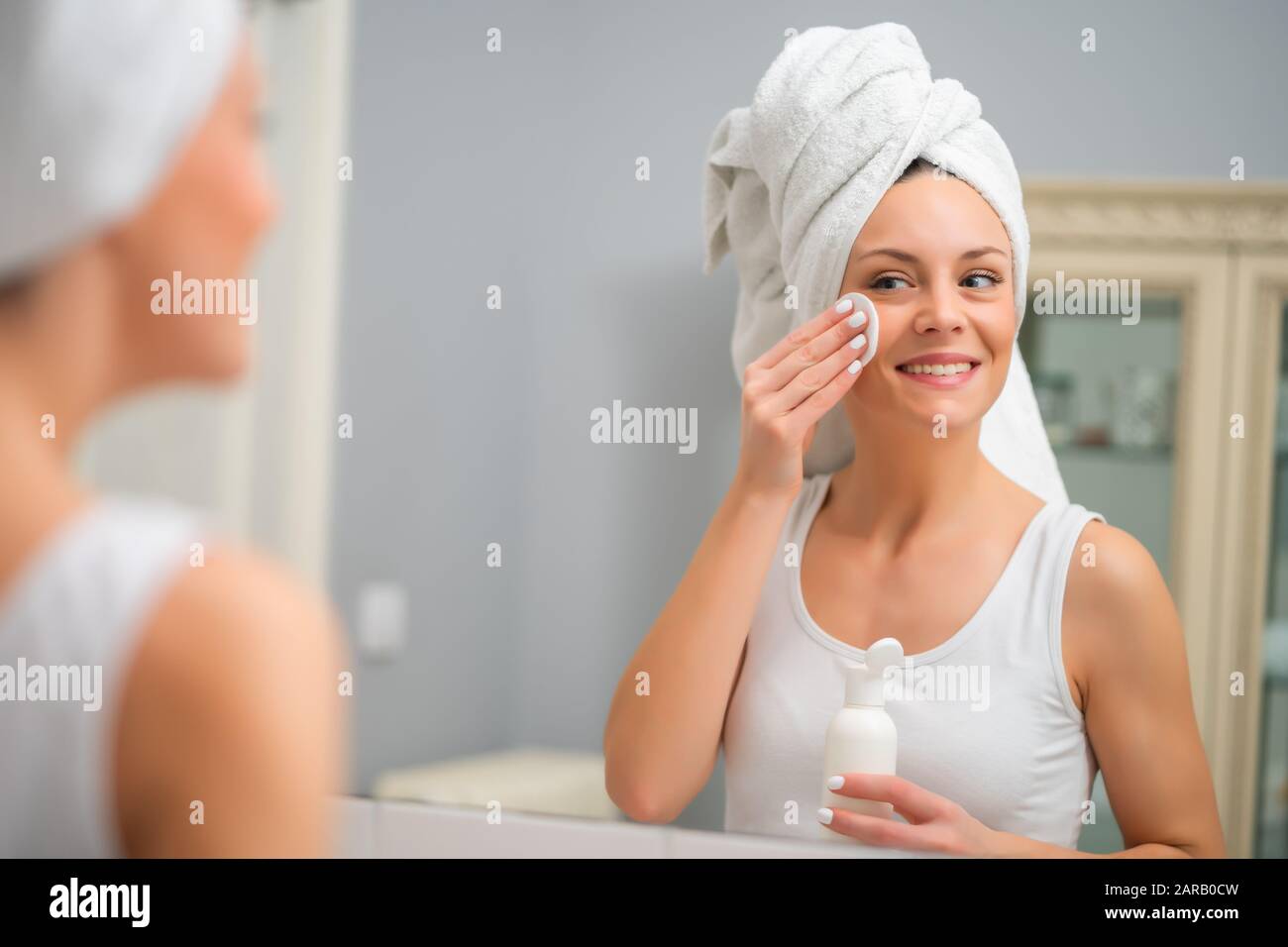 Portrait of young woman who is cleaning skin on her face Stock Photo ...