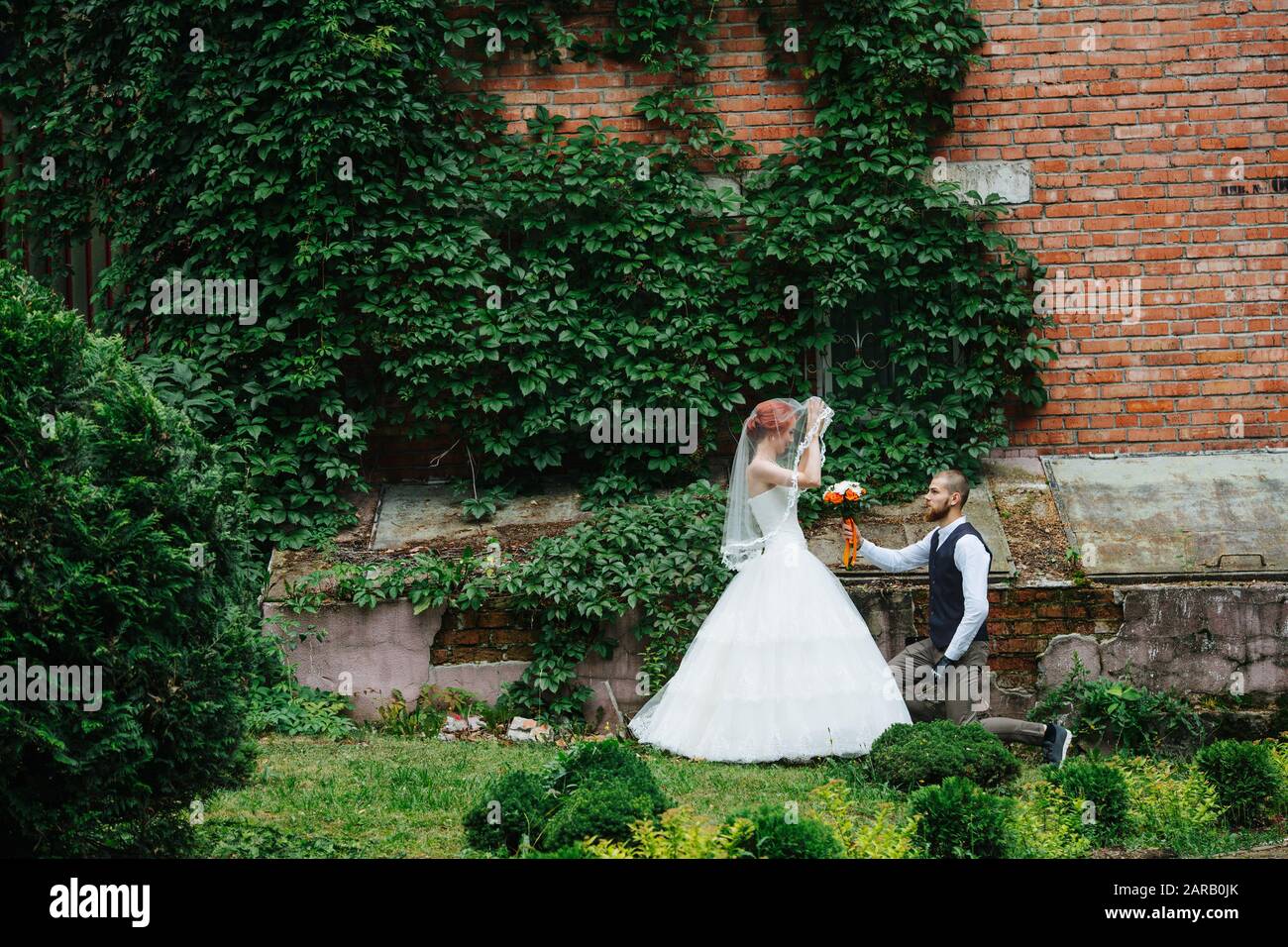 Happy wedding couple brick wall hi-res stock photography and images - Alamy