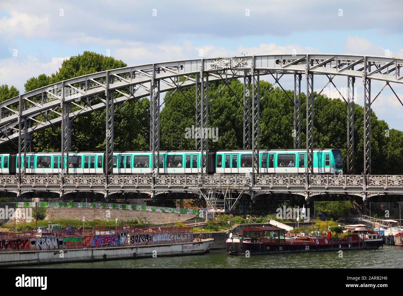 PARIS, FRANCE - JULY 24, 2011: People ride a Metro train across river ...