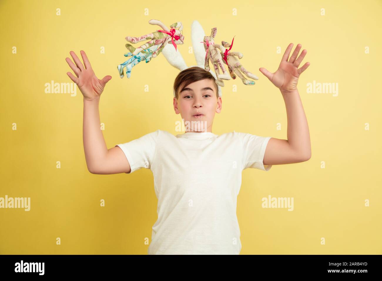 Having fun. Decorating. Caucasian boy as an Easter bunny on yellow ...