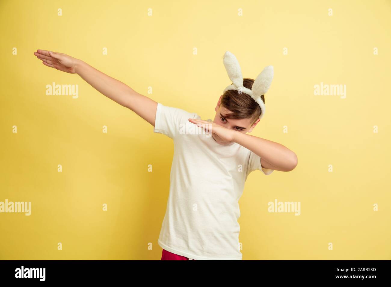 Dabbing, dab. Caucasian boy as an Easter bunny on yellow studio ...