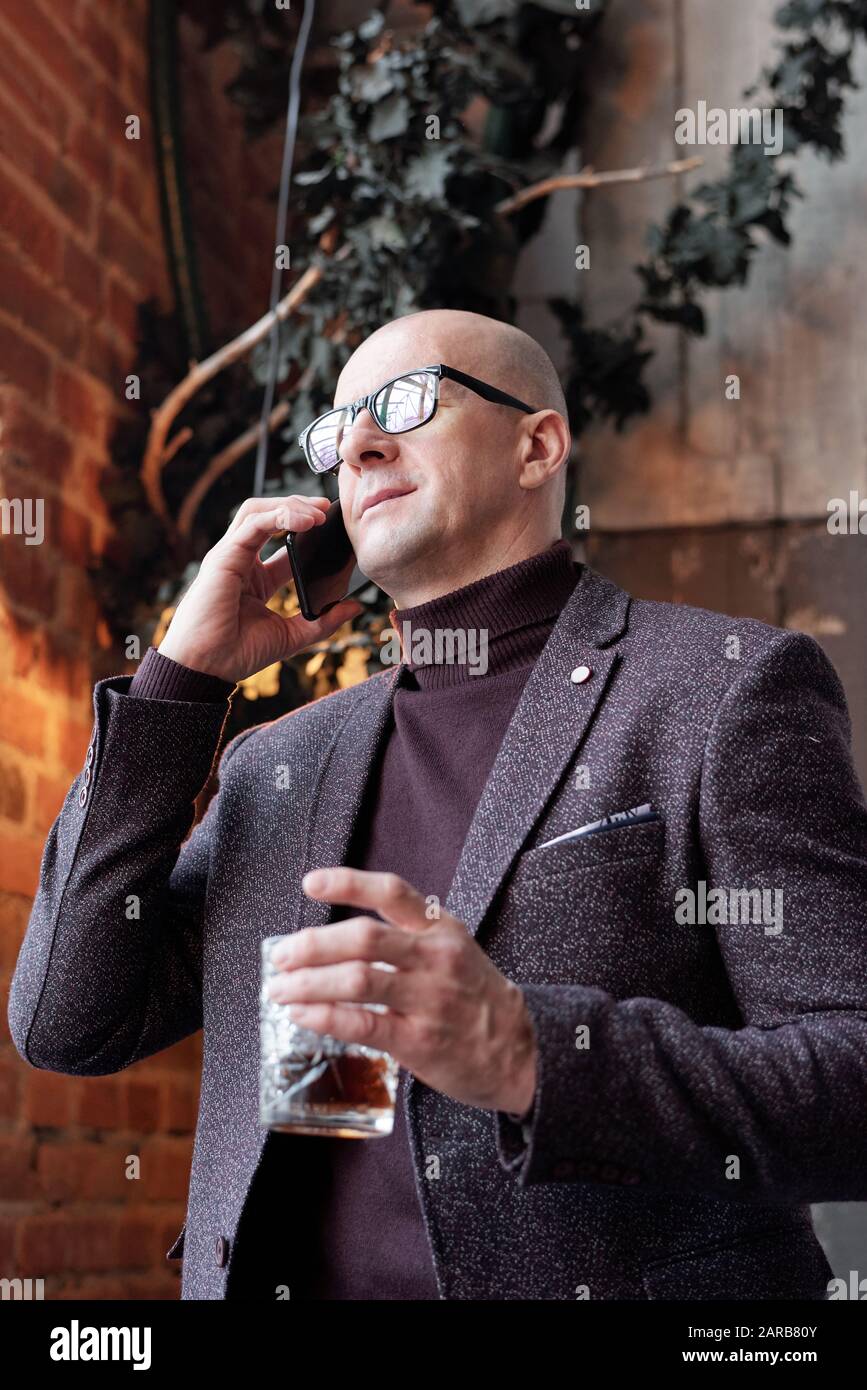 Drinking alcohol while answering call Stock Photo - Alamy