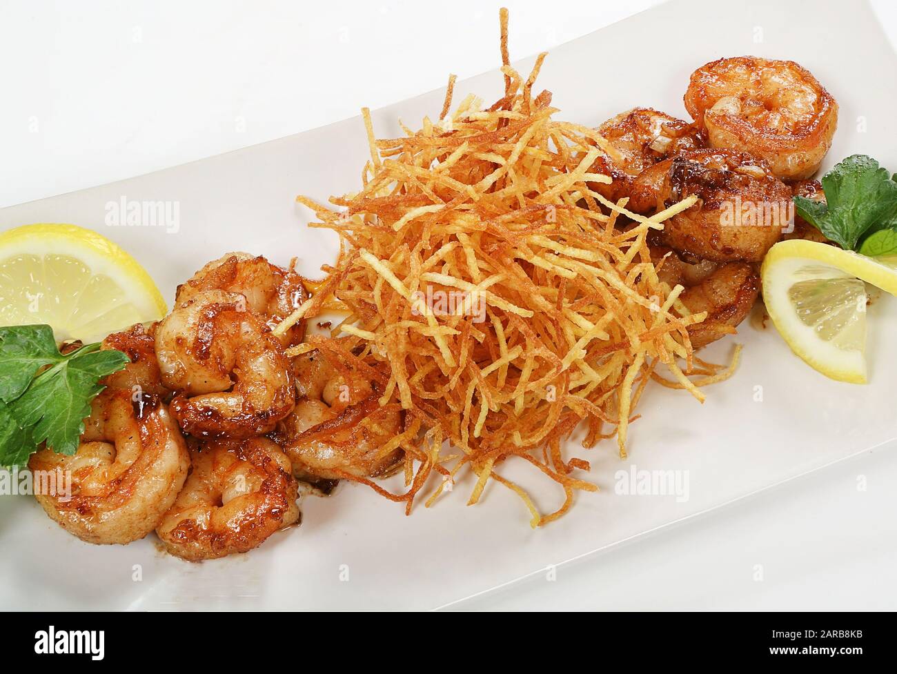Grilled tiger prawn with Pai potatoes, garnished with lemon and parsley ...