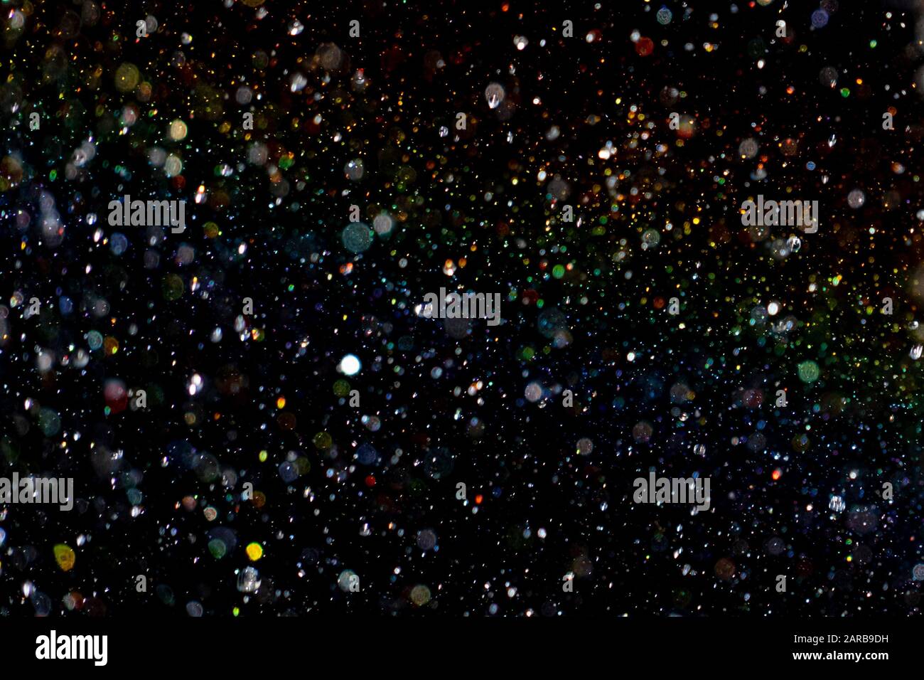 Rainbow spray splash drop on black background Stock Photo - Alamy