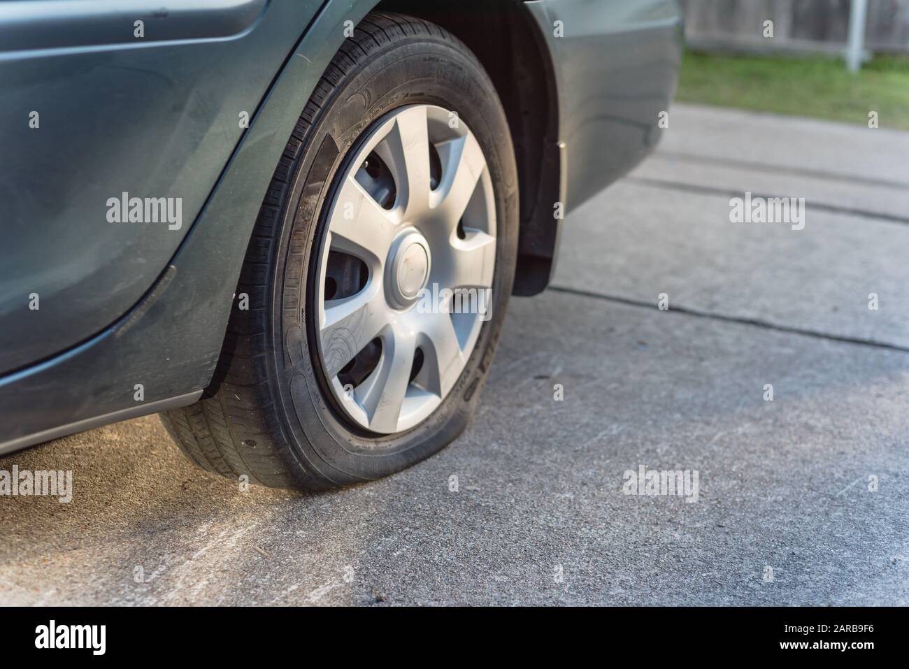 Flat Tire Driveway Rear View Of Flat Tire On Green Car On Driveway Of