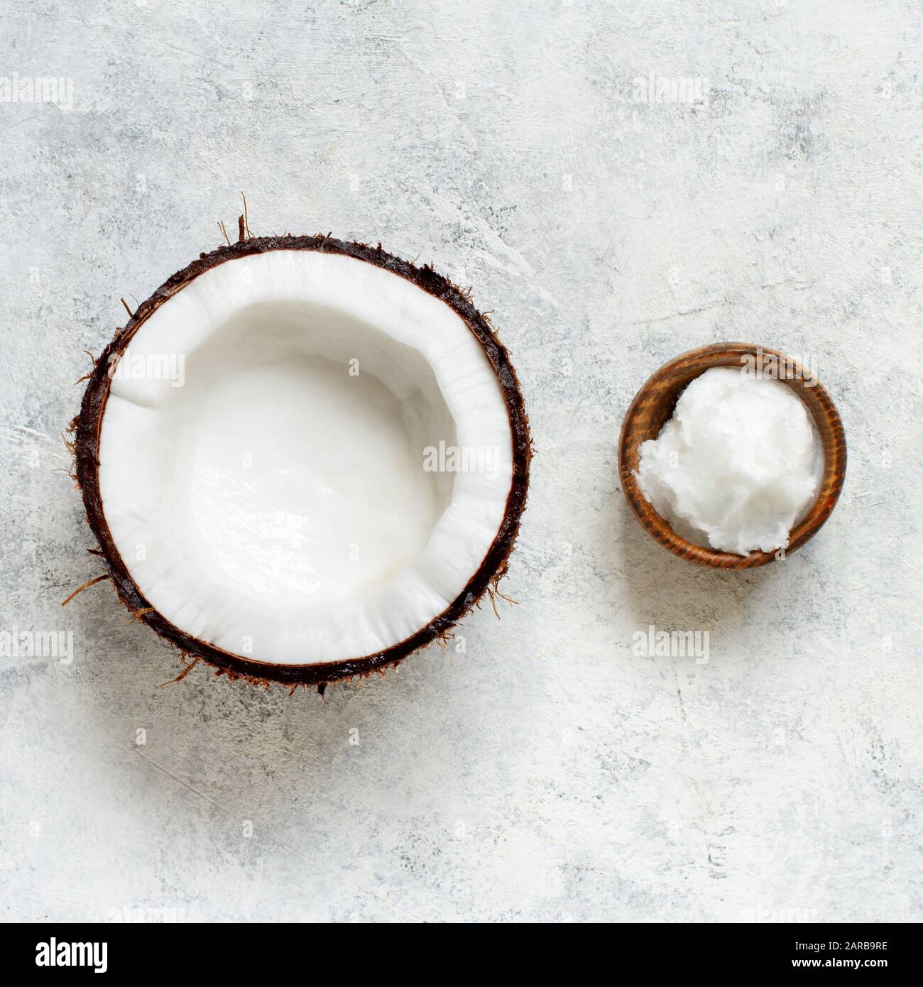 Coconut oil in a bowl and half of coconut top view Stock Photo - Alamy