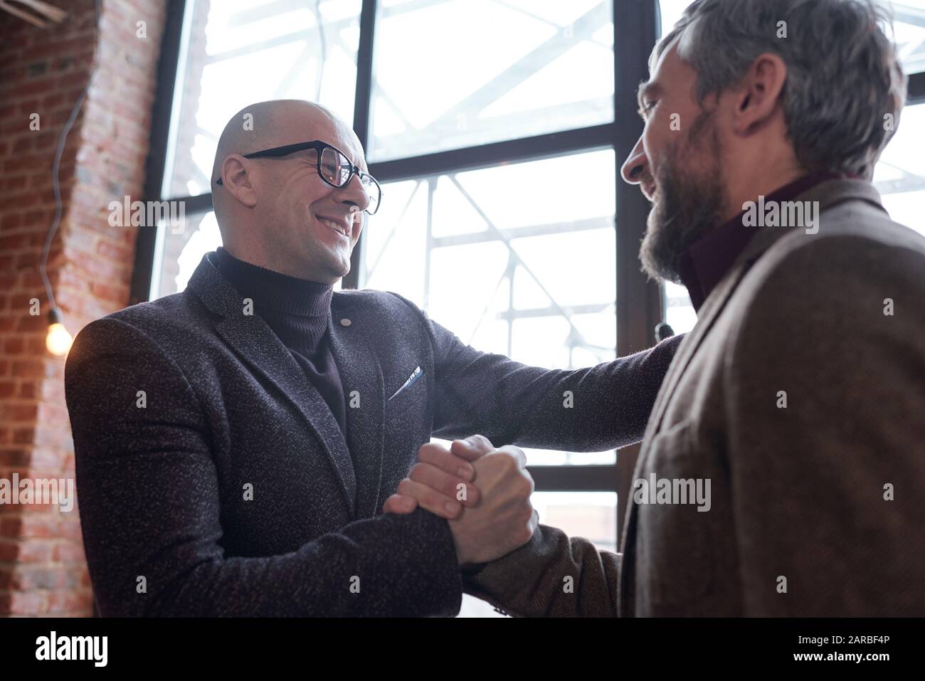 Male friends shaking hands Stock Photo - Alamy