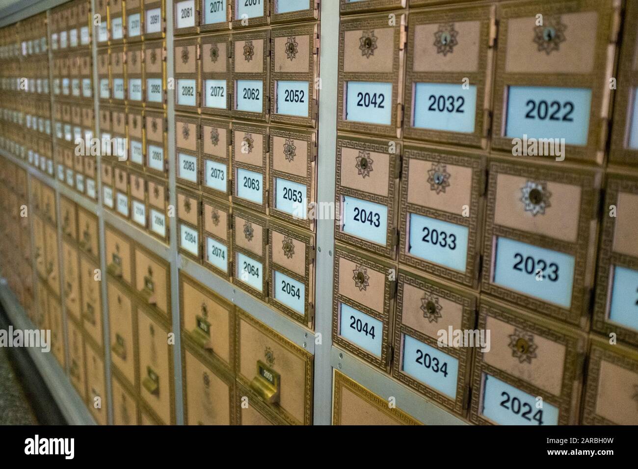 The wall of bronze post office locker boxes with personal numbers of ...
