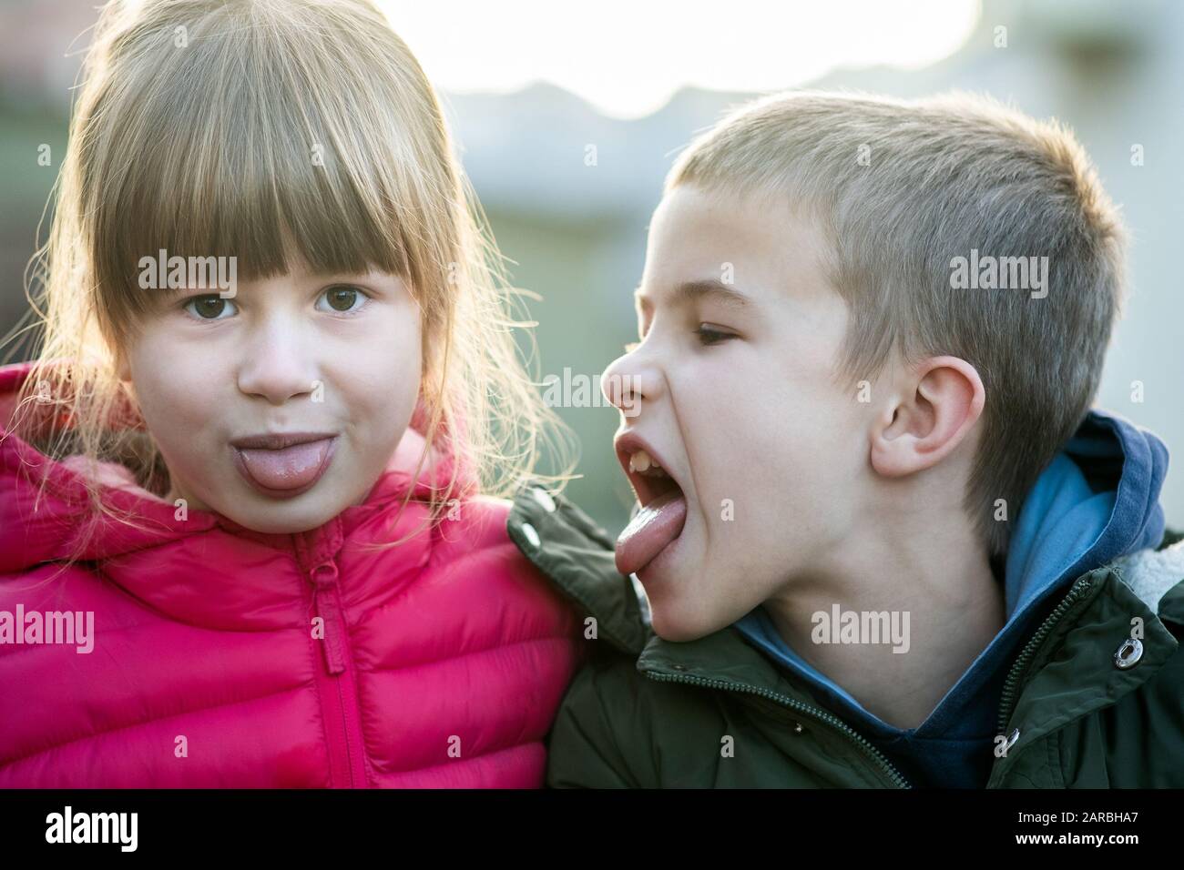Two children boy and girl fooling around having fun together outdoors ...