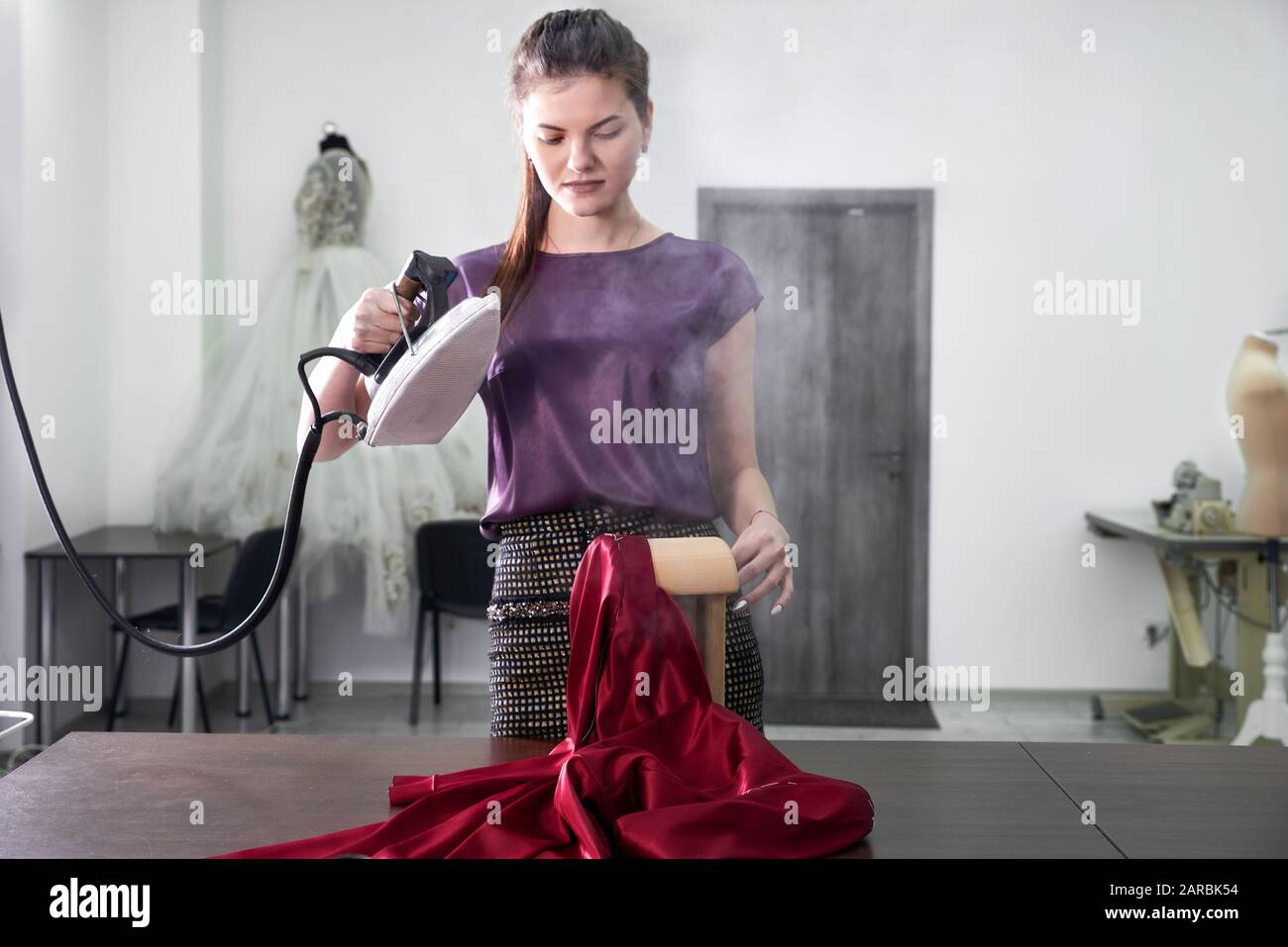 Woman irons cloth in factory hi-res stock photography and images - Alamy