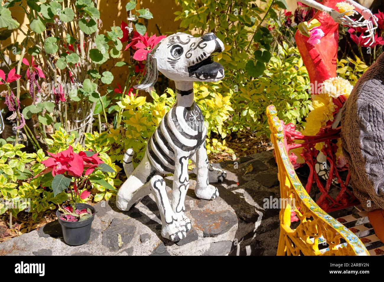 Dog statue, in Day of Dead bone art style, in a garden in a courtyard ...