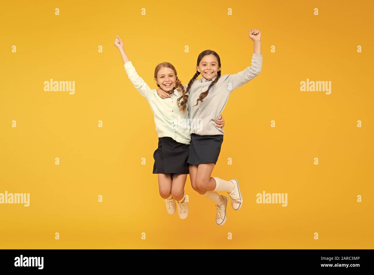 Happy winners. Little school girls jumping and making winner gestures ...