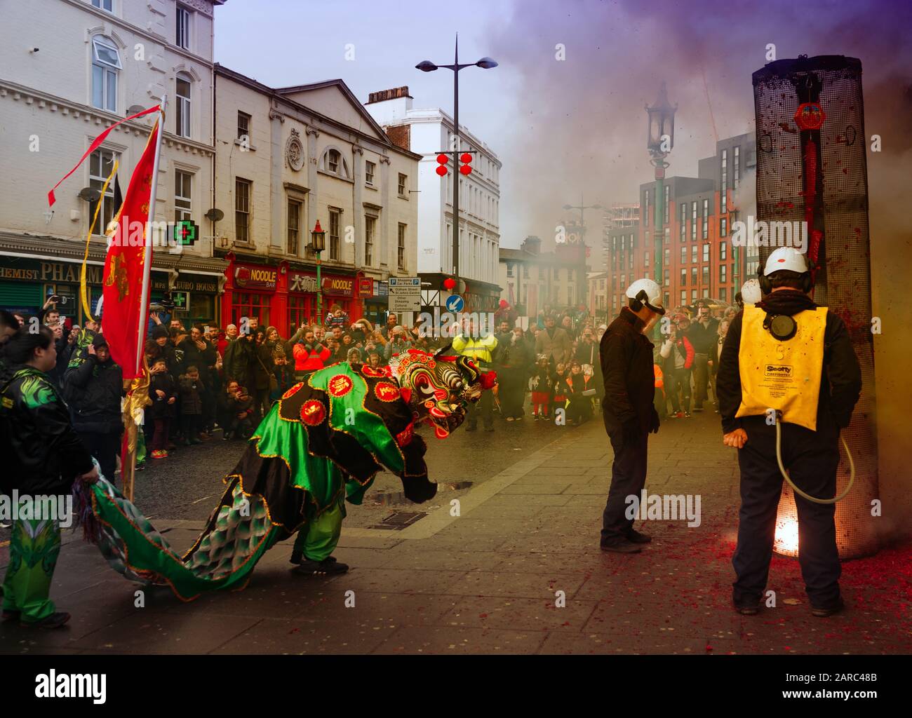 Firecrackers being lit in a protective cage as thousands of people ...