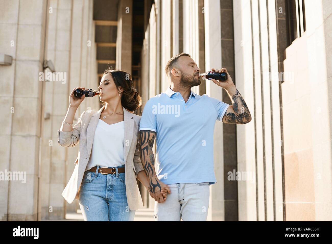 A fashionable young couple of lovers enjoying the taste of Coca Cola ...