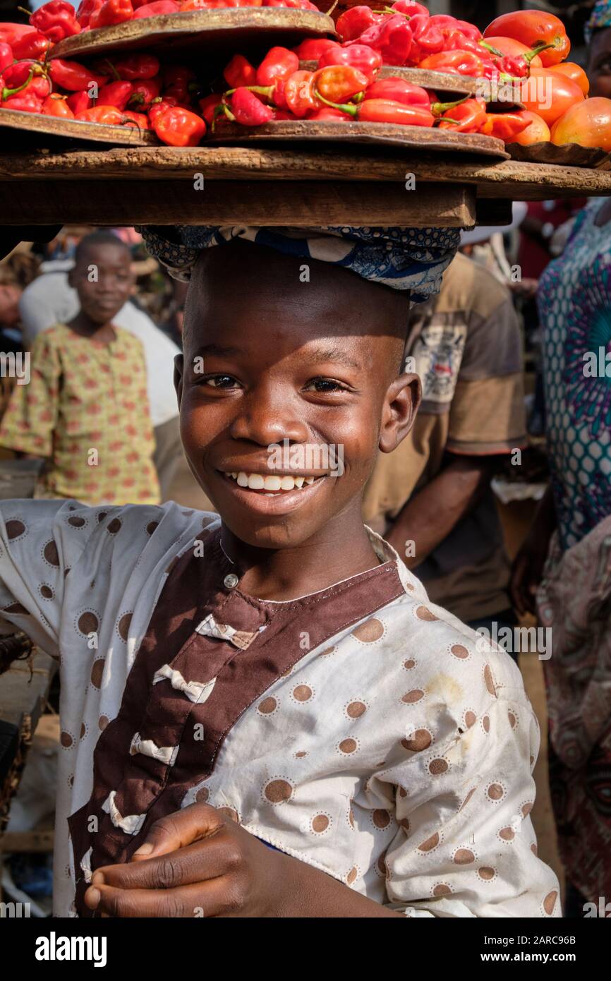 Boy with a tray on his head selling vegetables in a street market Stock ...