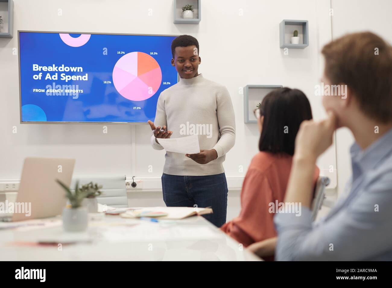 Portrait of young African man giving presentation on marketing during ...