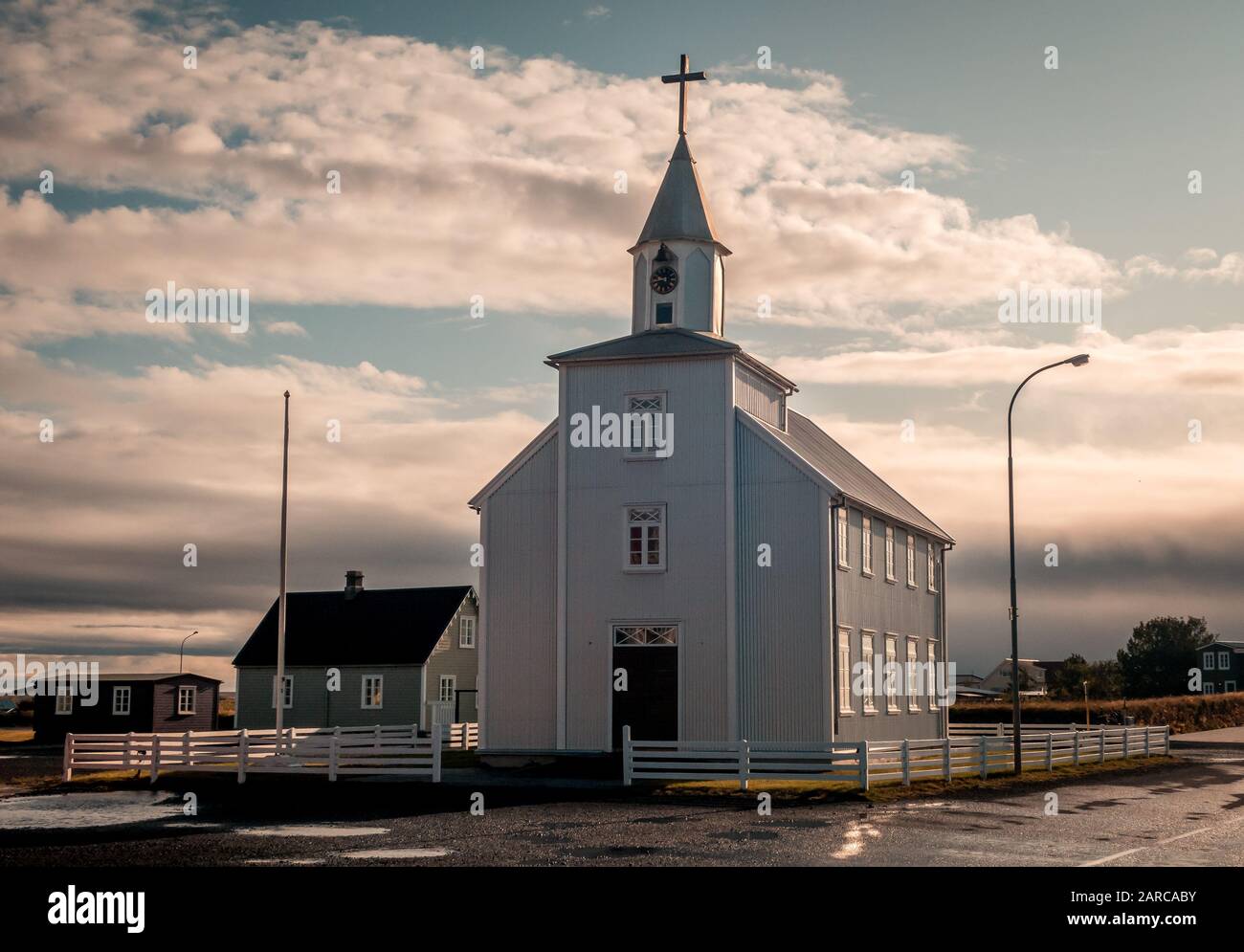 White church with a cross on the top and beautiful clouds in the ...