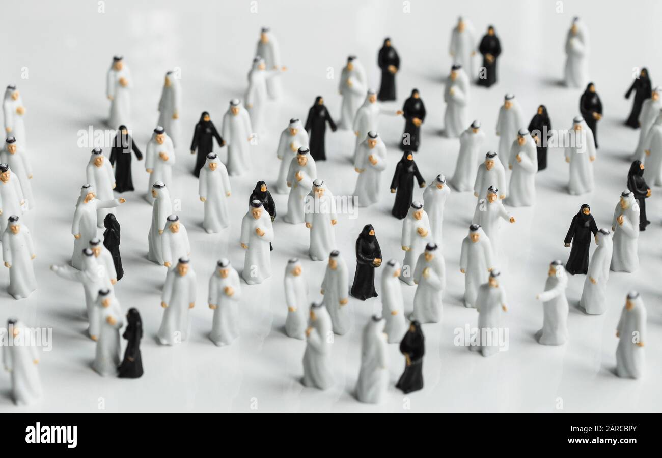 High angle shot of small statues of Muslim people in traditional black ...