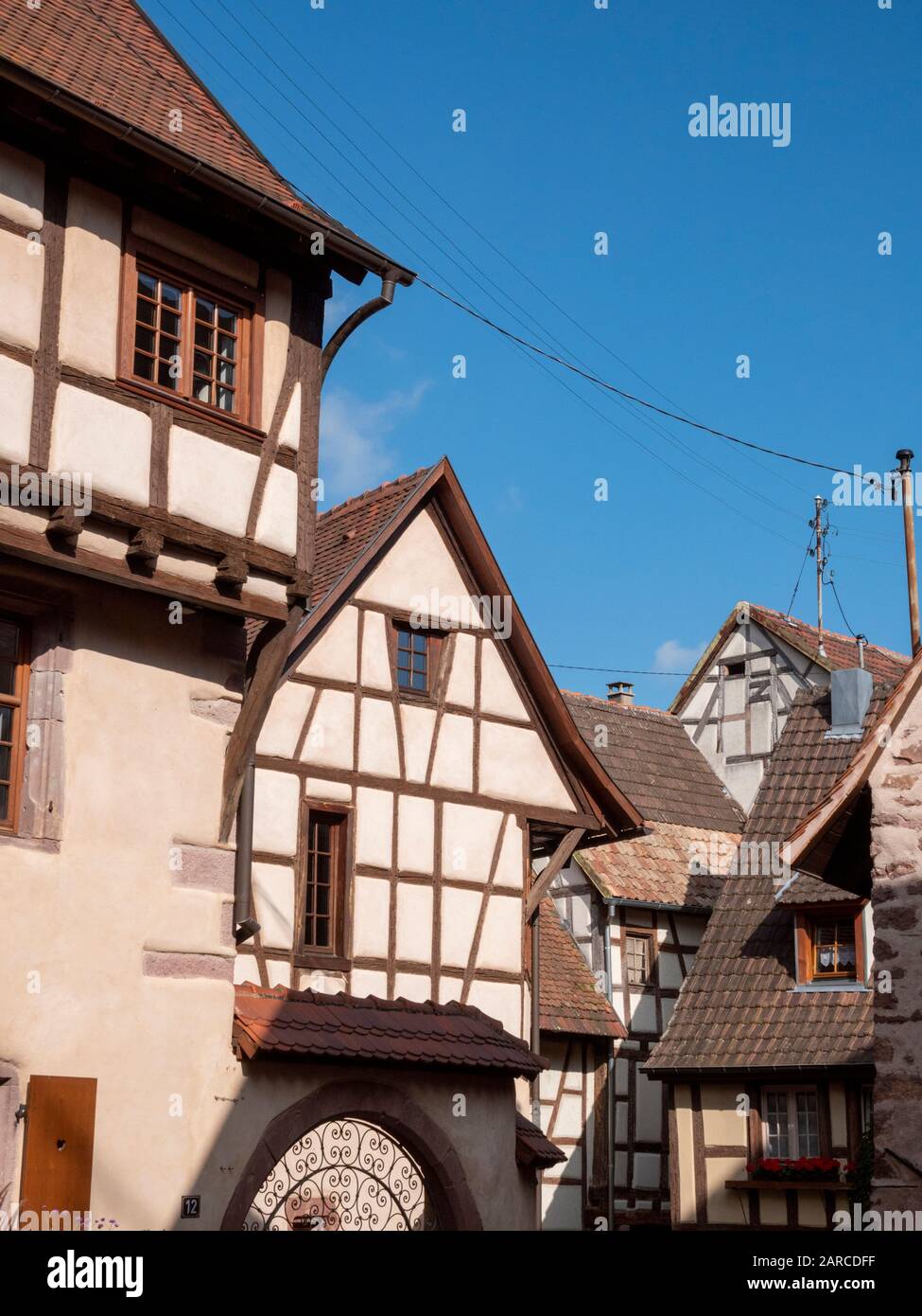 Medieval half timbered buildings and a church bell tower in Colmar ...