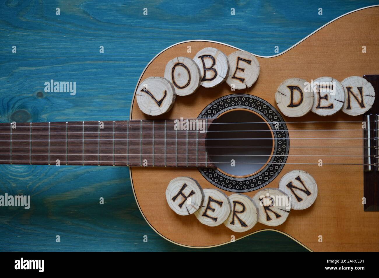 guitar on teal wooden background with wood pieces on it lettering the ...