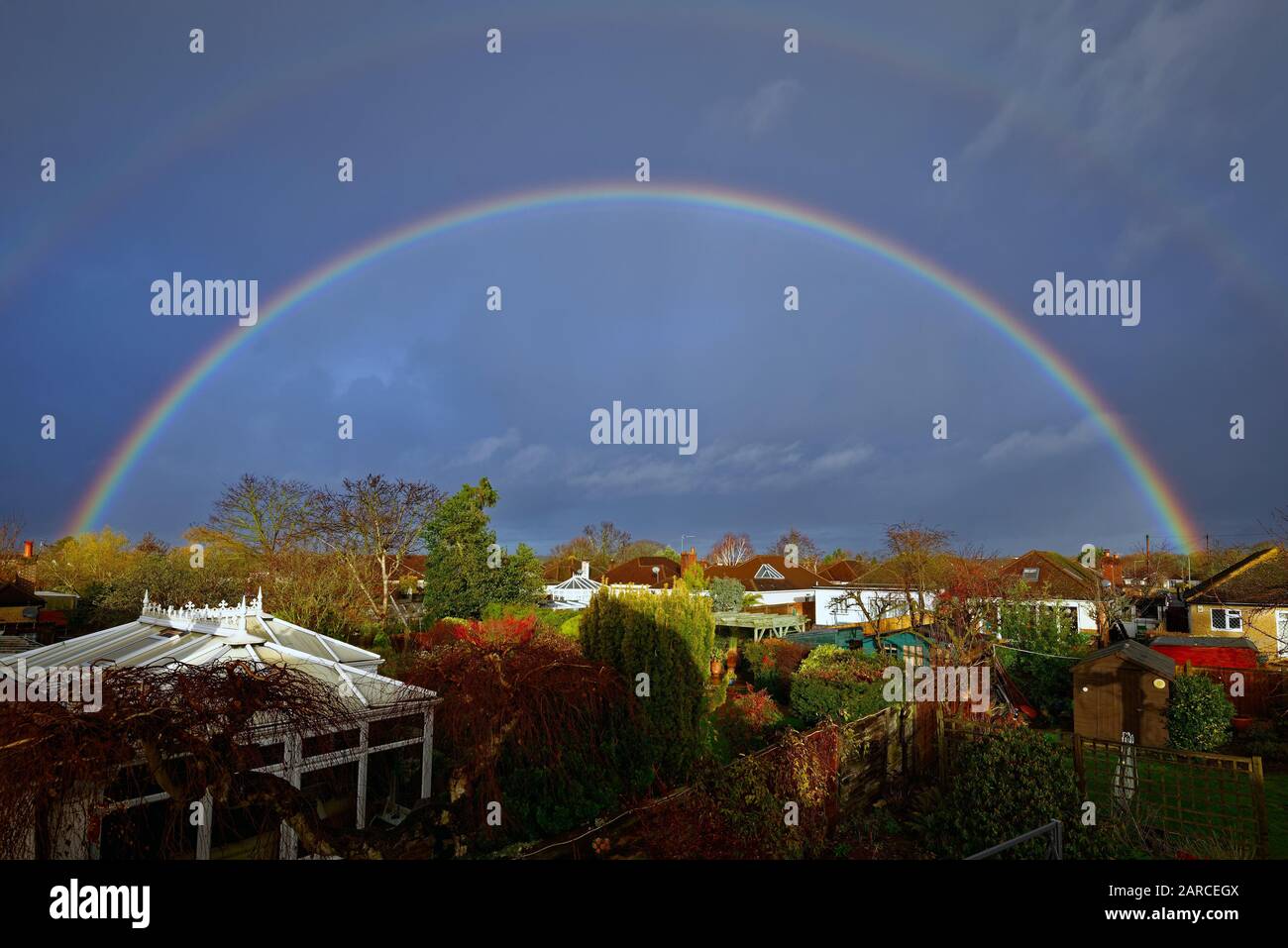 A complete rainbow formed over the rooftops of suburban houses in ...