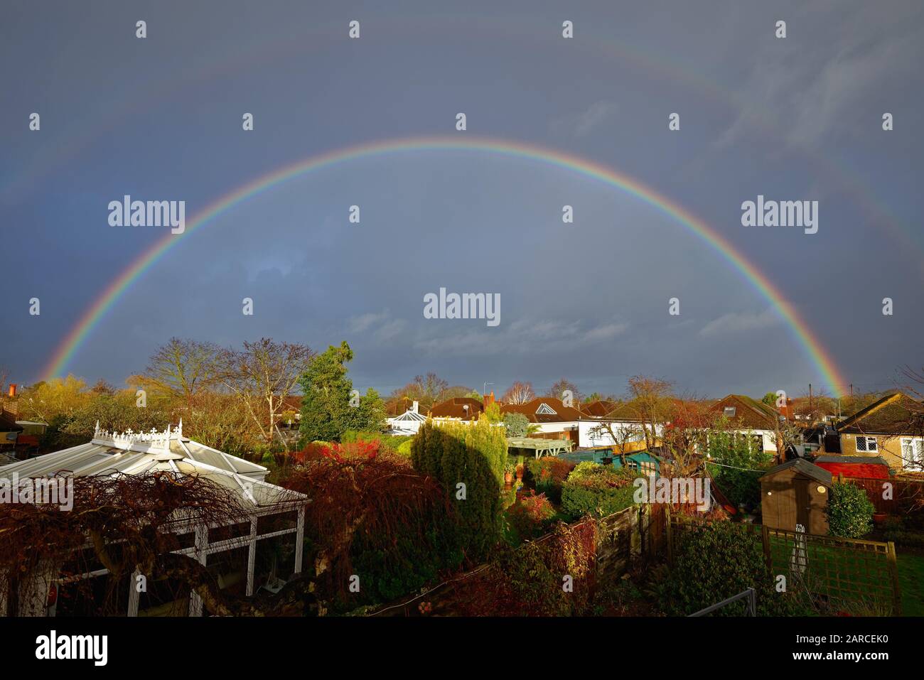 A complete rainbow formed over the rooftops of suburban houses in ...