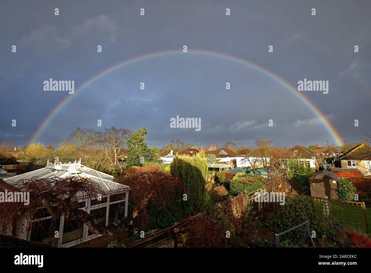 A complete rainbow formed over the rooftops of suburban houses in ...