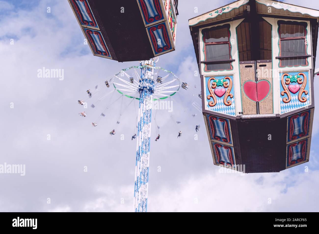 Wide angle shot of a carousel next to two buildings turned upside down ...