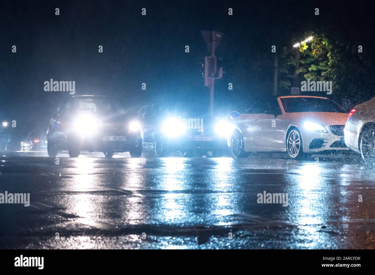 Low angle shot of several cars on the street at night Stock Photo - Alamy