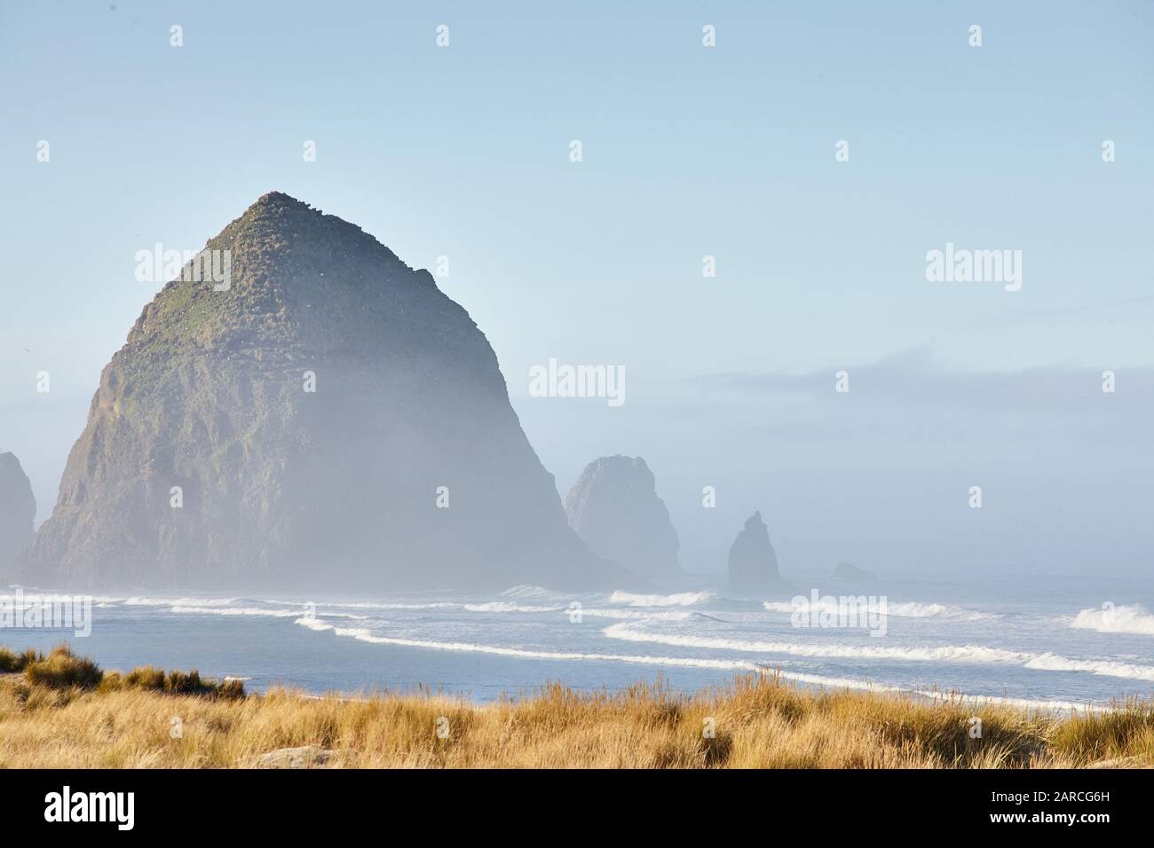 Scenery of the Haystack Rock in the morning fog at Cannon Beach, Oregon ...