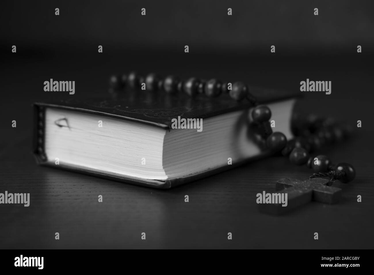 Greyscale shot of the Bible with a cross necklace over the book Stock ...