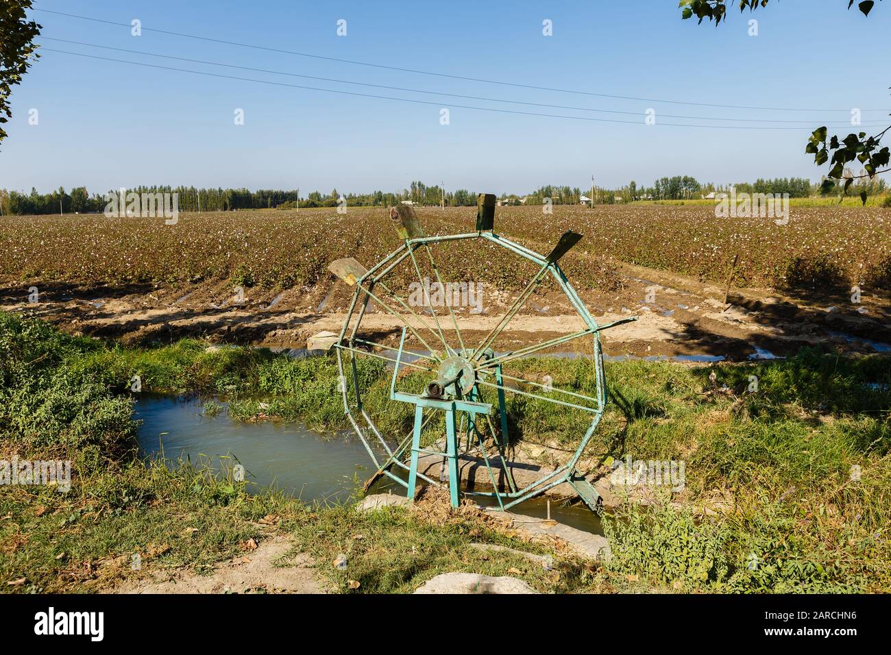 Water turbine on a cotton field. Water wheel and channel for watering ...