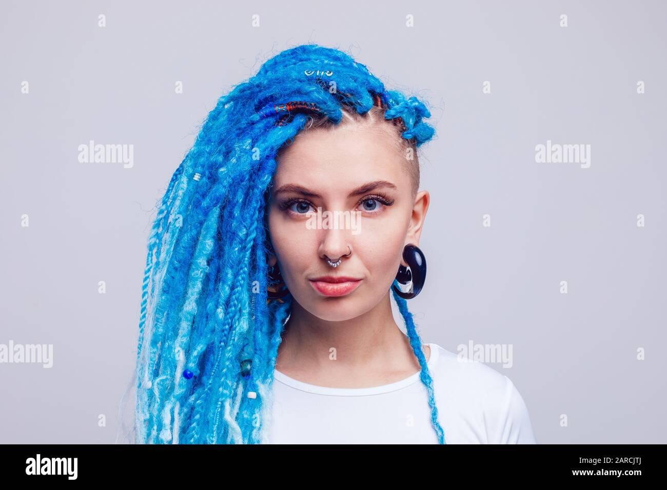 Portrait of a woman with blue dreadlocks and a piercing. Informal young ...