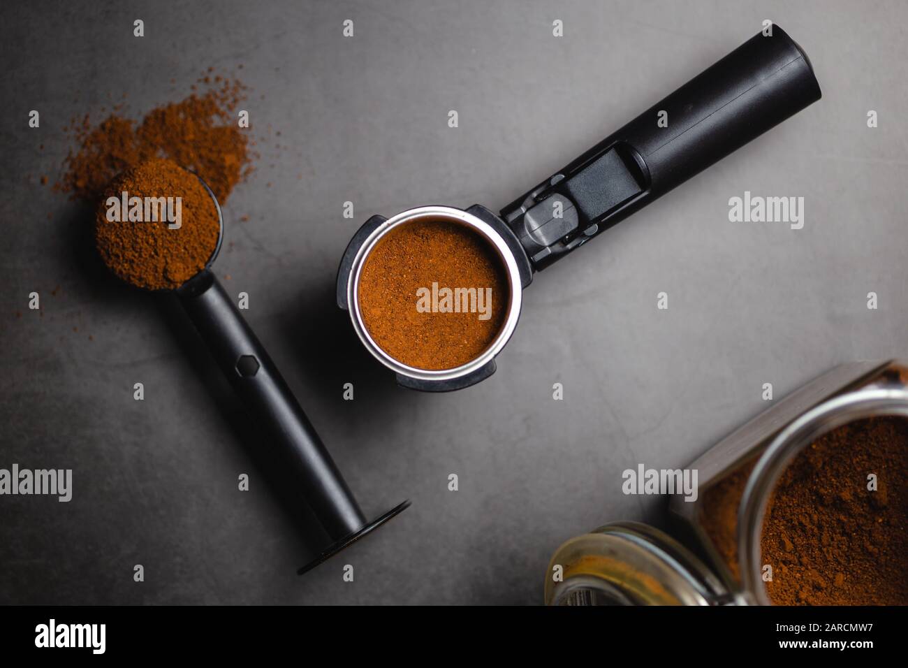 Coffee maker, portafilter with ground coffee and spoon over black ...