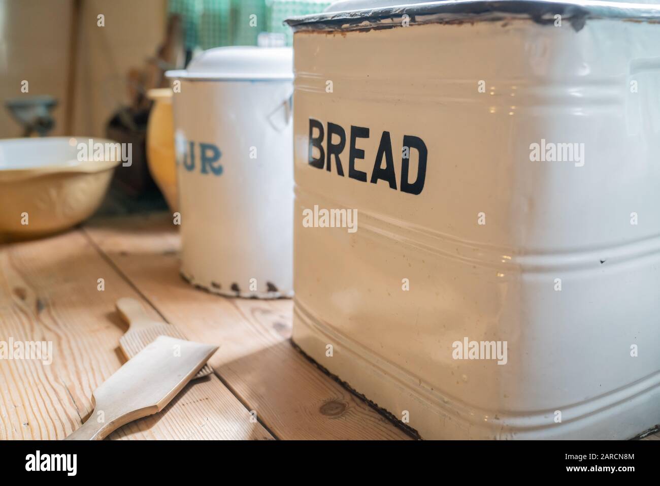 Old-fashioned kitchen scene with wooden bench with utensils and enamel ...