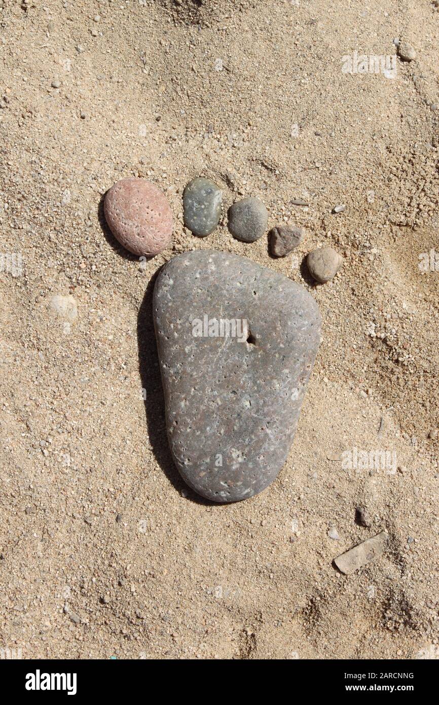 Foot designed with stones on the beach Stock Photo - Alamy