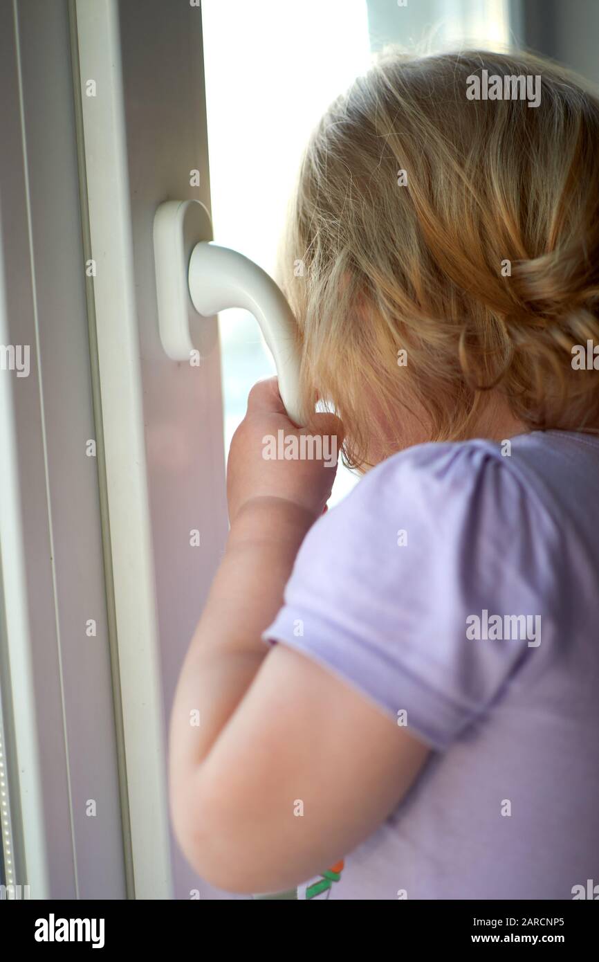 A little girl standing in front of a window Stock Photo - Alamy