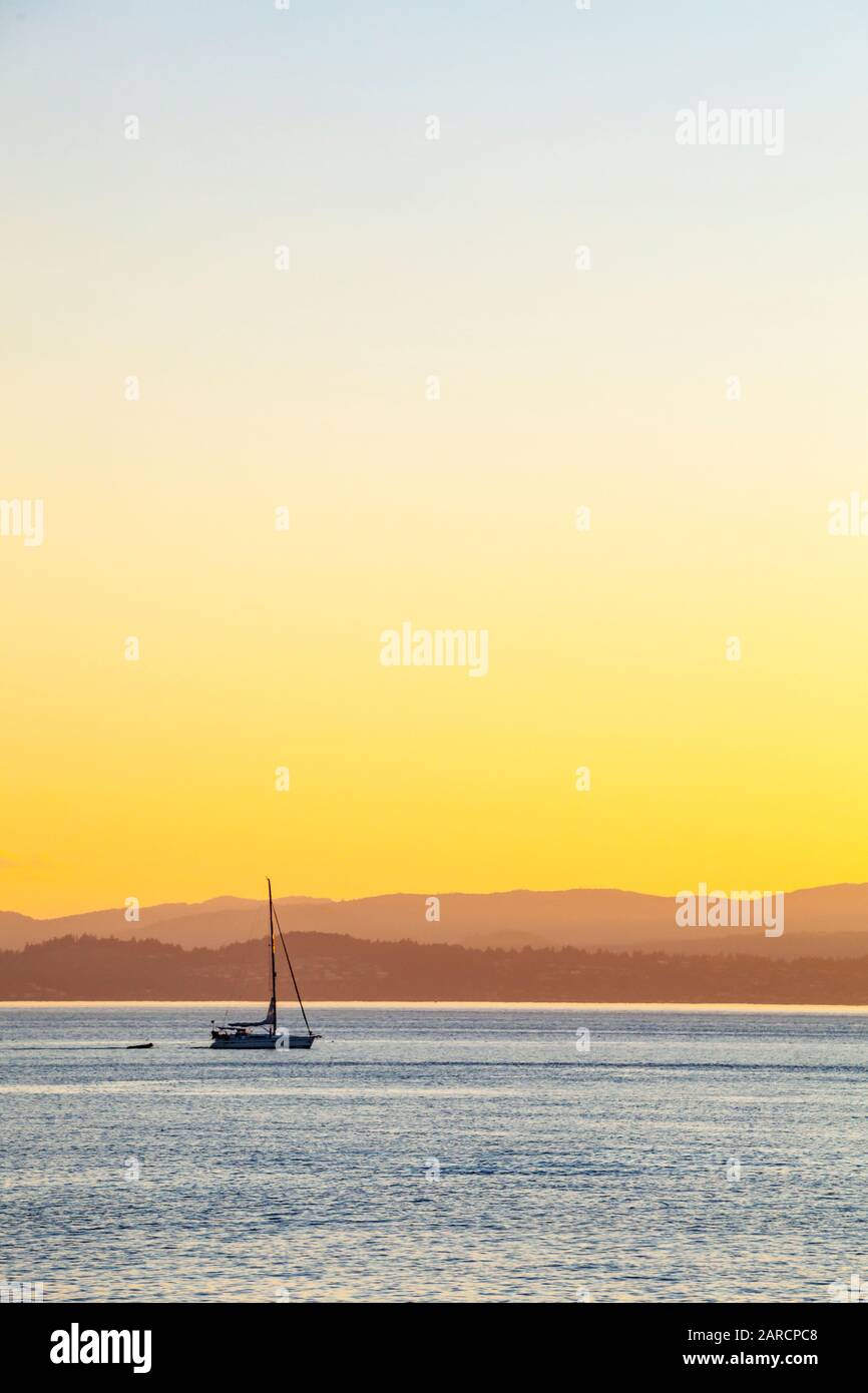 A sailboat motoring through the Haro Strait between San Juan Island and ...