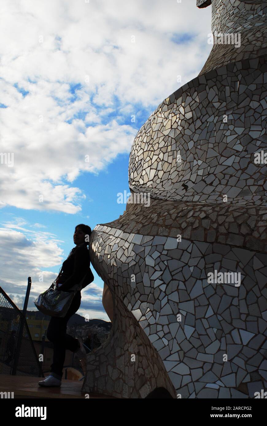 A woman poses against the iconic decorative chimneys on the roof of ...