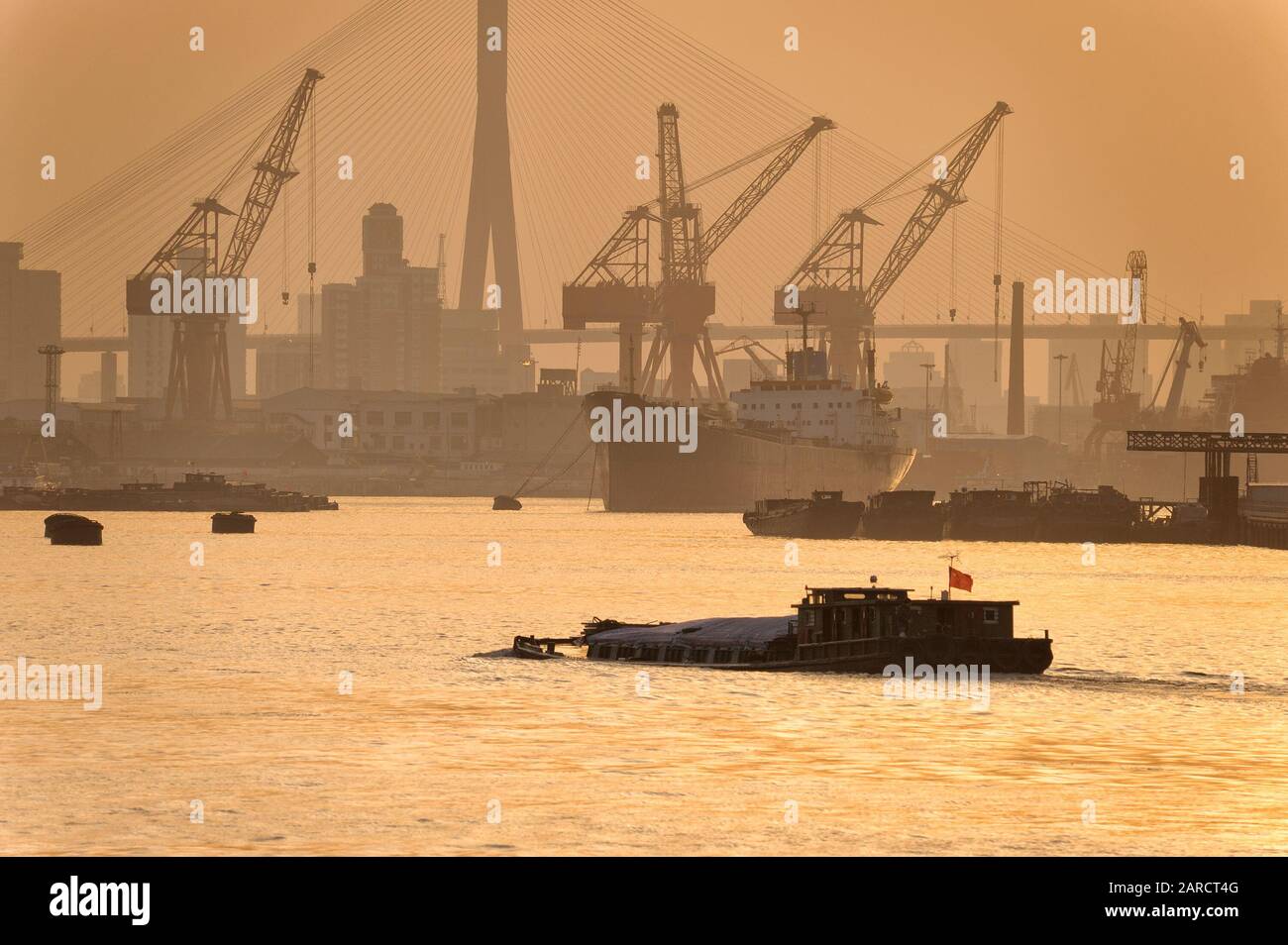 Overloaded barge entering in Shanghai's harbor.Natural light but looks ...