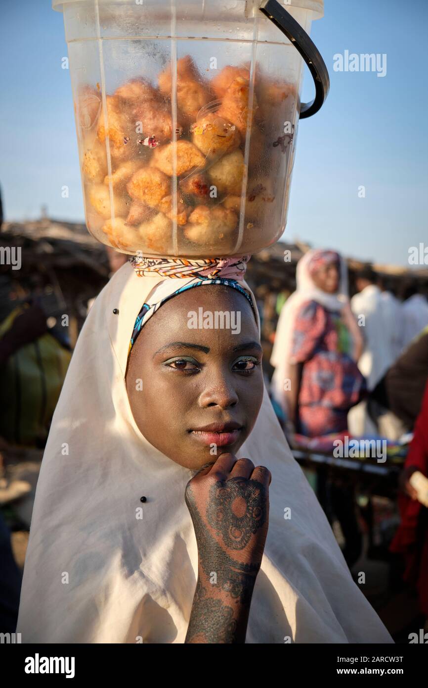 Portrait of a girl with her hands decorated with henna selling food in ...