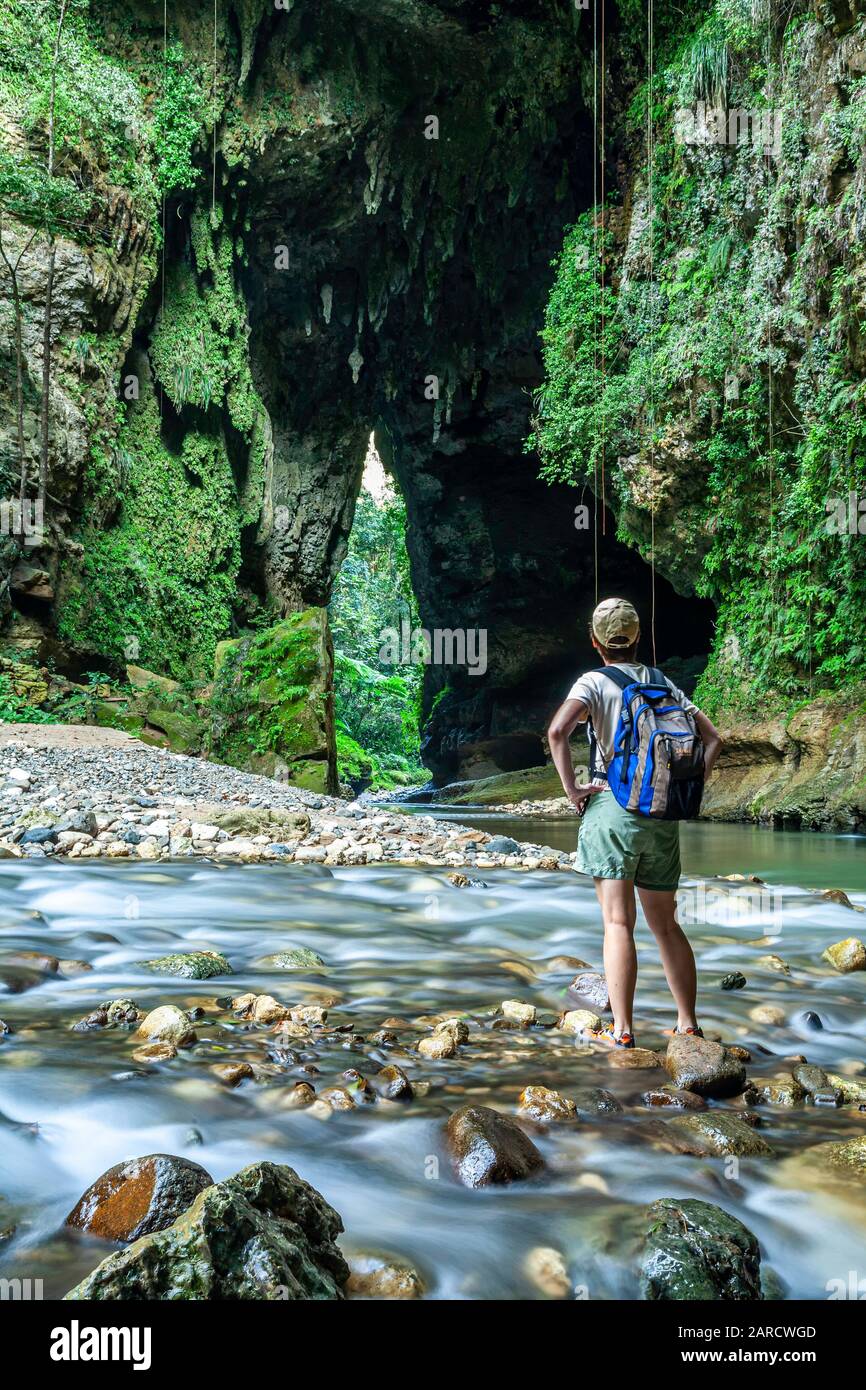 Hiker on Tanama River and limestone cave, near Utuado, Puerto Rico ...