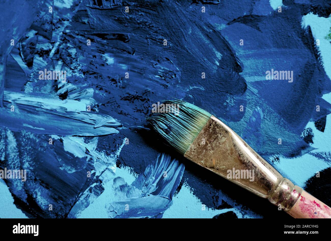 Blue paints on palette with artist paint brush. Texture mixed oil ...