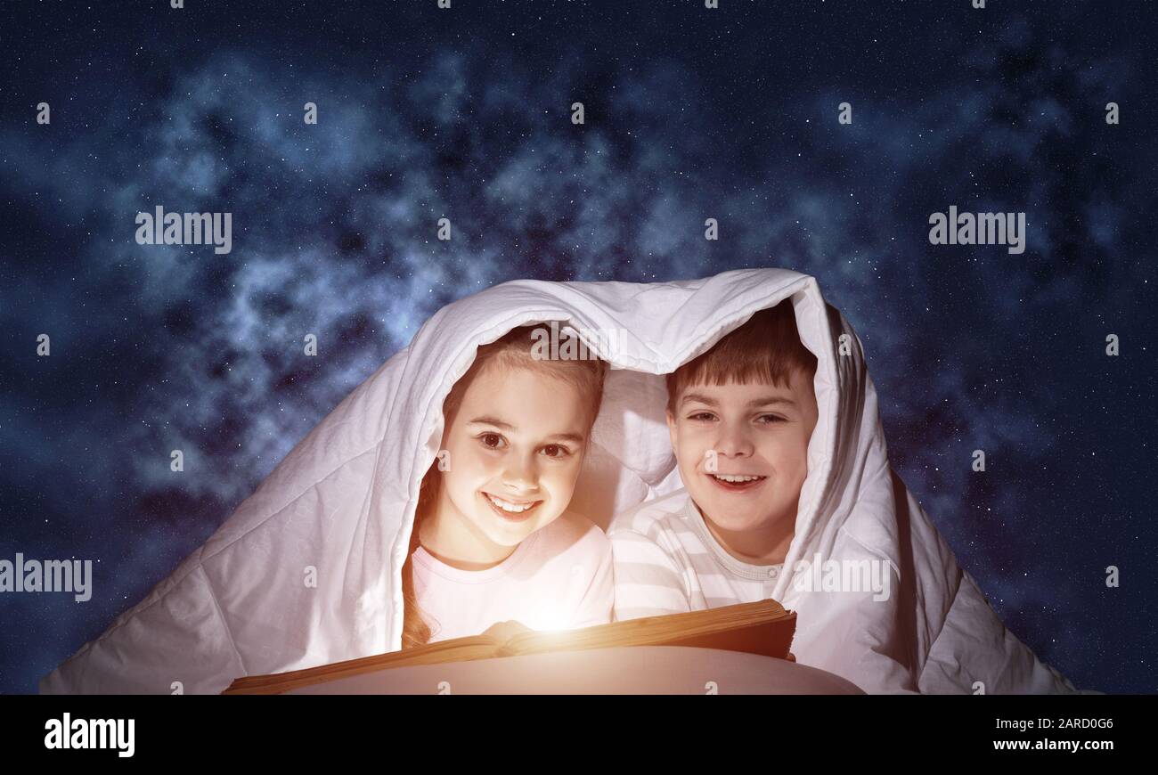 Happy children with flashlight hiding Stock Photo - Alamy